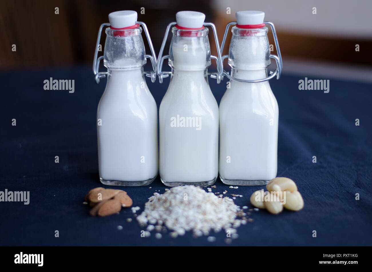 Almond milk, cashew nut milk and oat milk standing together with ...
