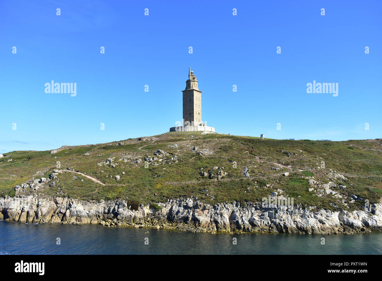 Tower of Hercules. Roman lighthouse in use. Bay, cliff and hill. Sunny ...