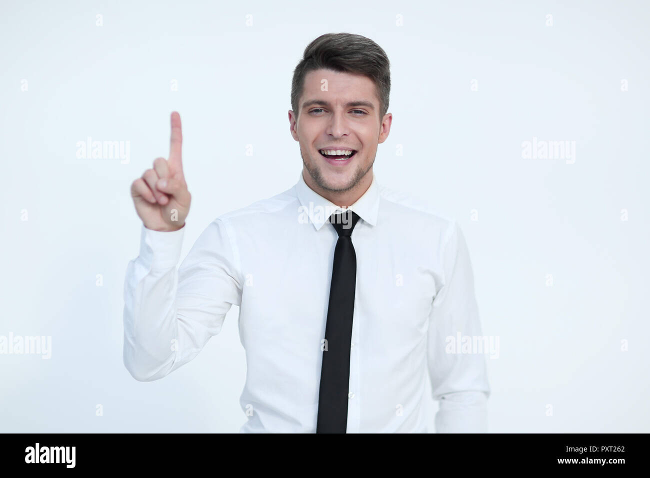 Smiling man pointing upwards and looking at camera Stock Photo - Alamy