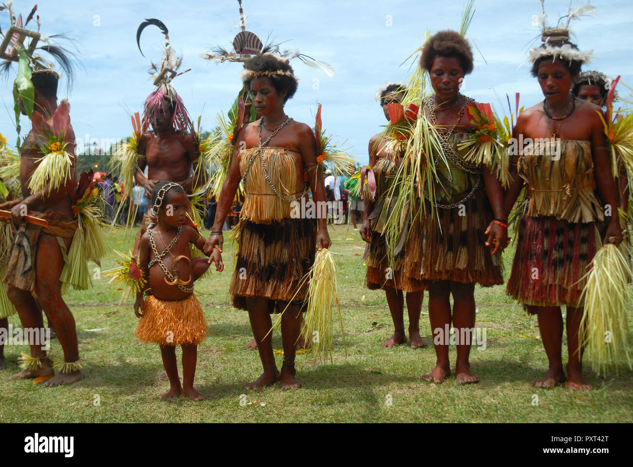 Colourfully dressed and face painted women dancing as part of a Sing ...