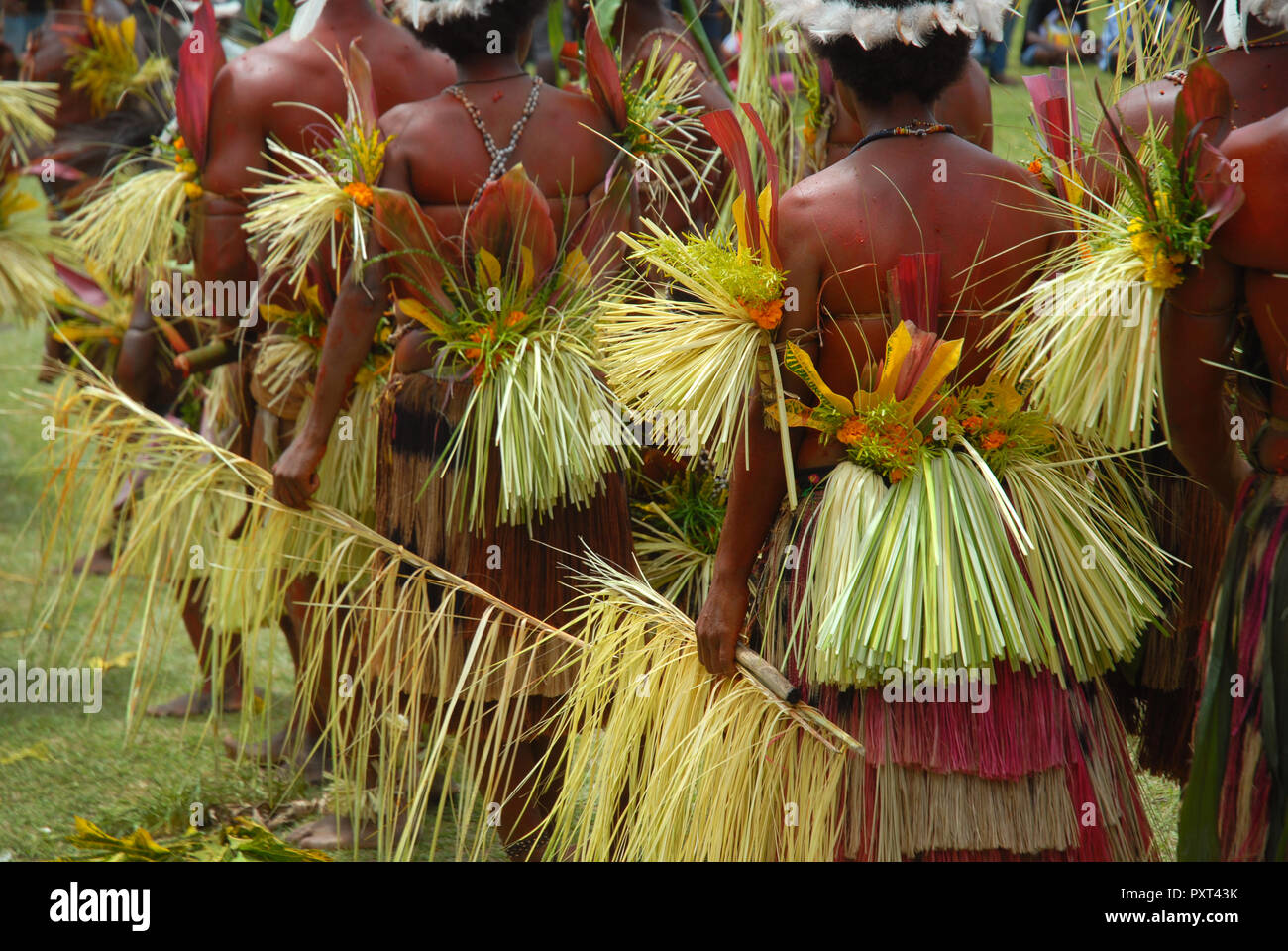 Colourfully dressed and face painted women dancing as part of a Sing ...