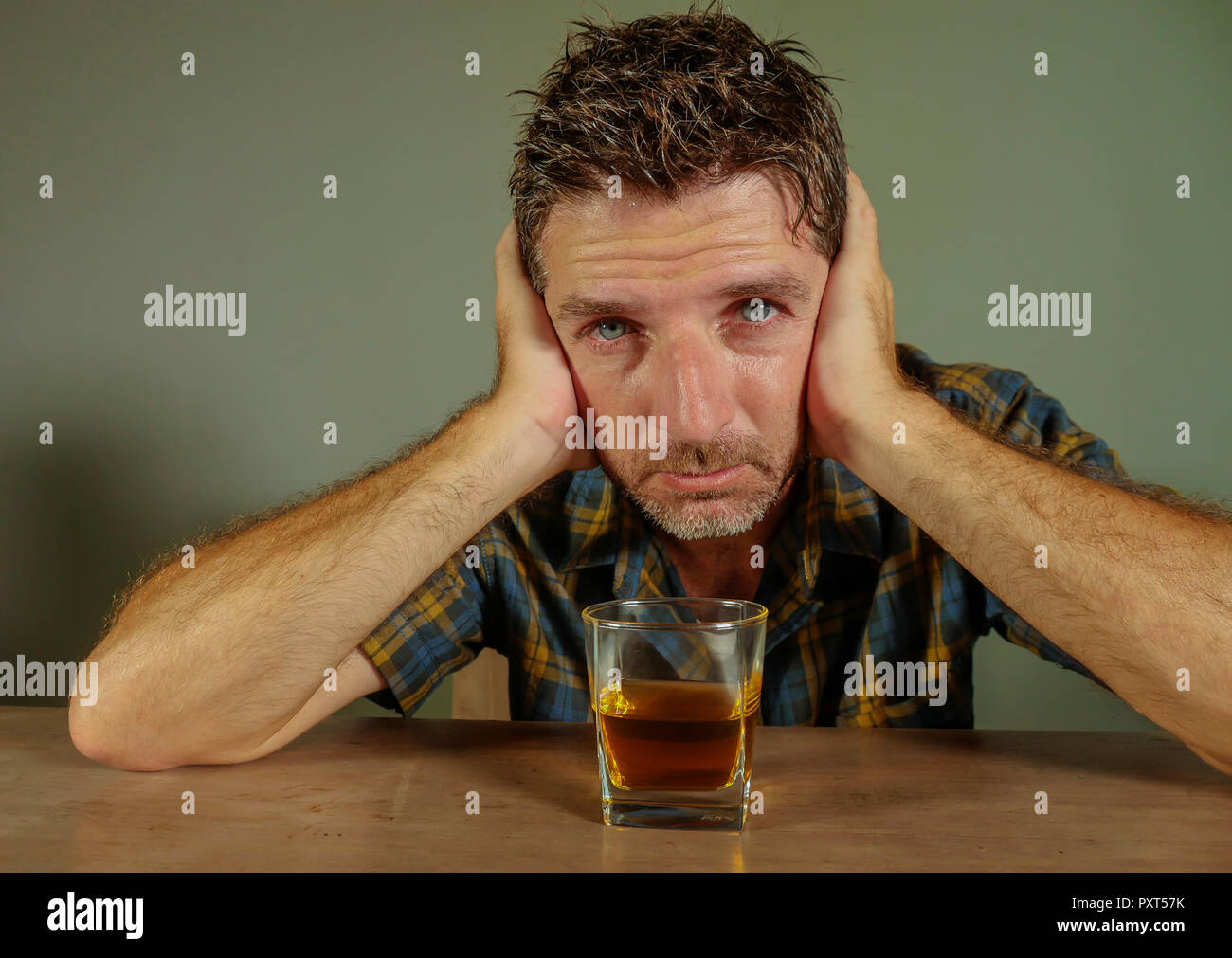 isolated portrait of young drunk addict and alcoholic man drinking whiskey glass intoxicated ...