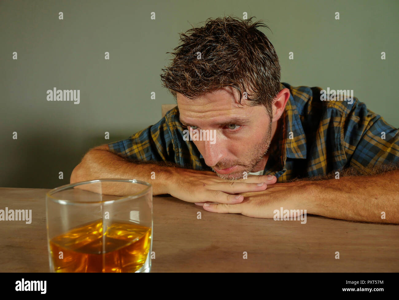 isolated portrait of young drunk addict and alcoholic man drinking whiskey glass intoxicated ...