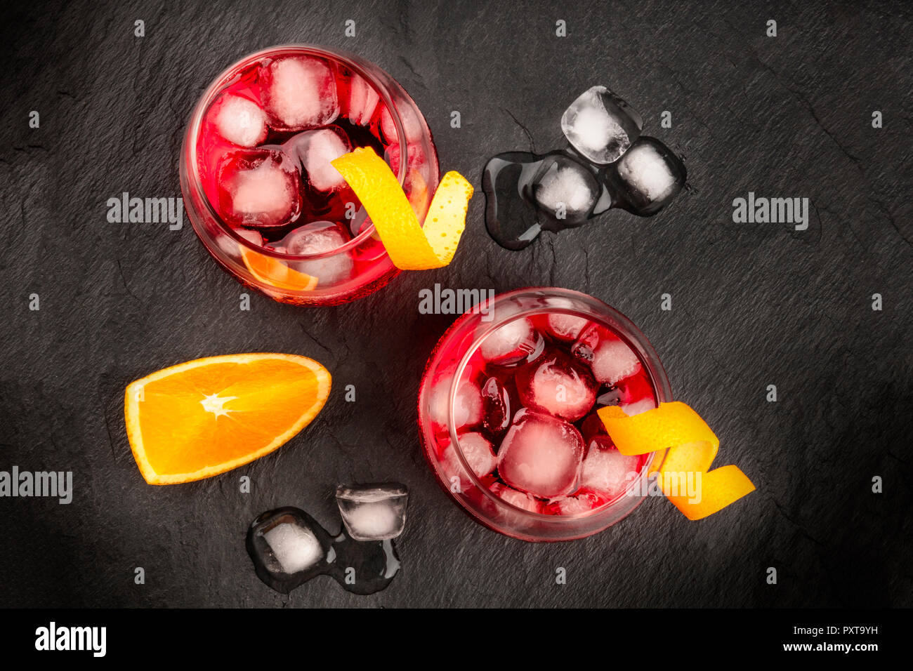 Two vibrant cocktails with campari and orange zest garnishes, shot from ...