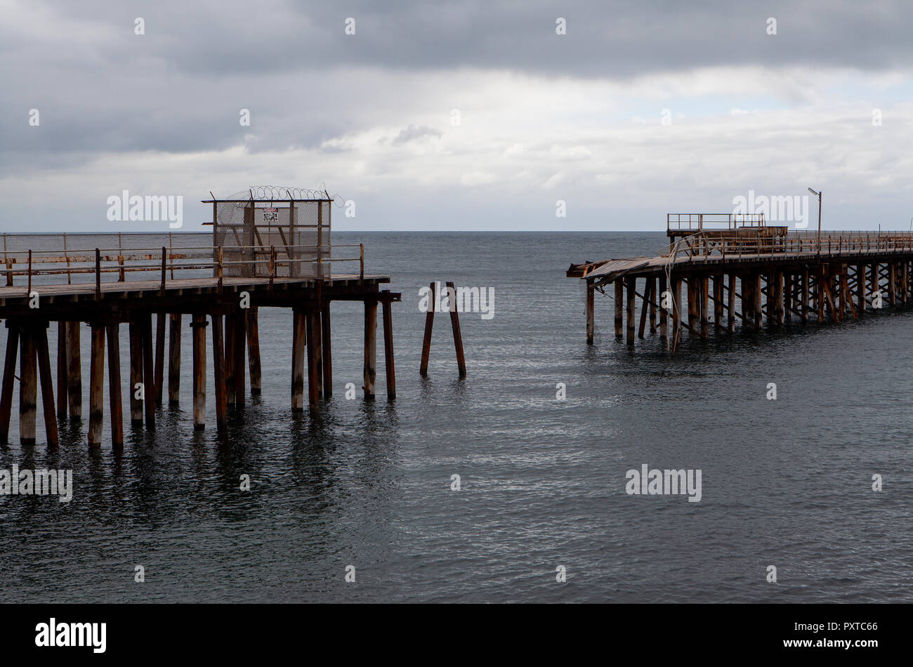 A broken and derelict pier with one set of supports remaining isolated ...
