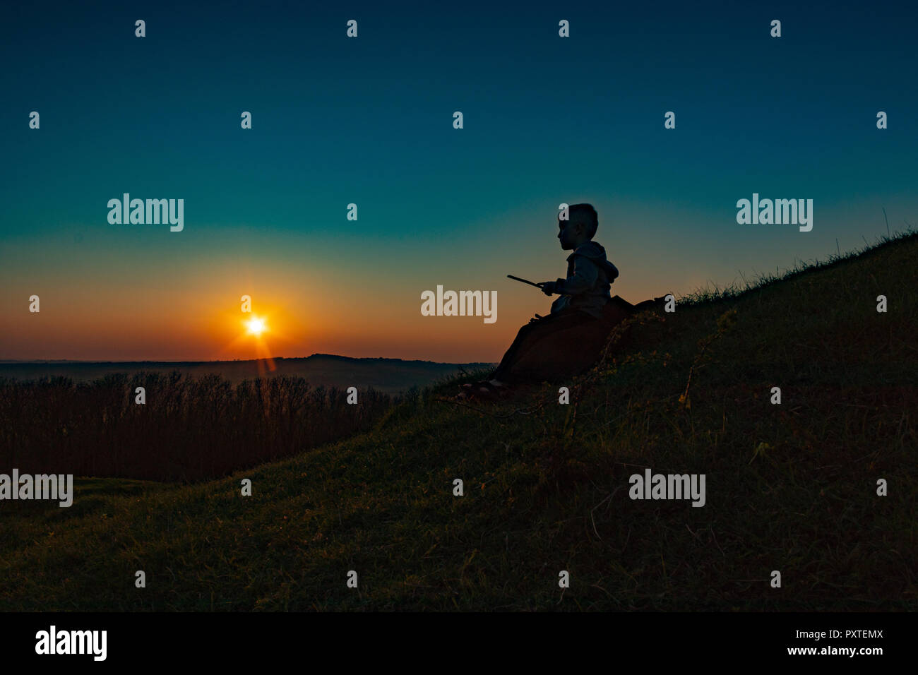 Wizard boy watching sunset at Old Winchester Hill Stock Photo - Alamy