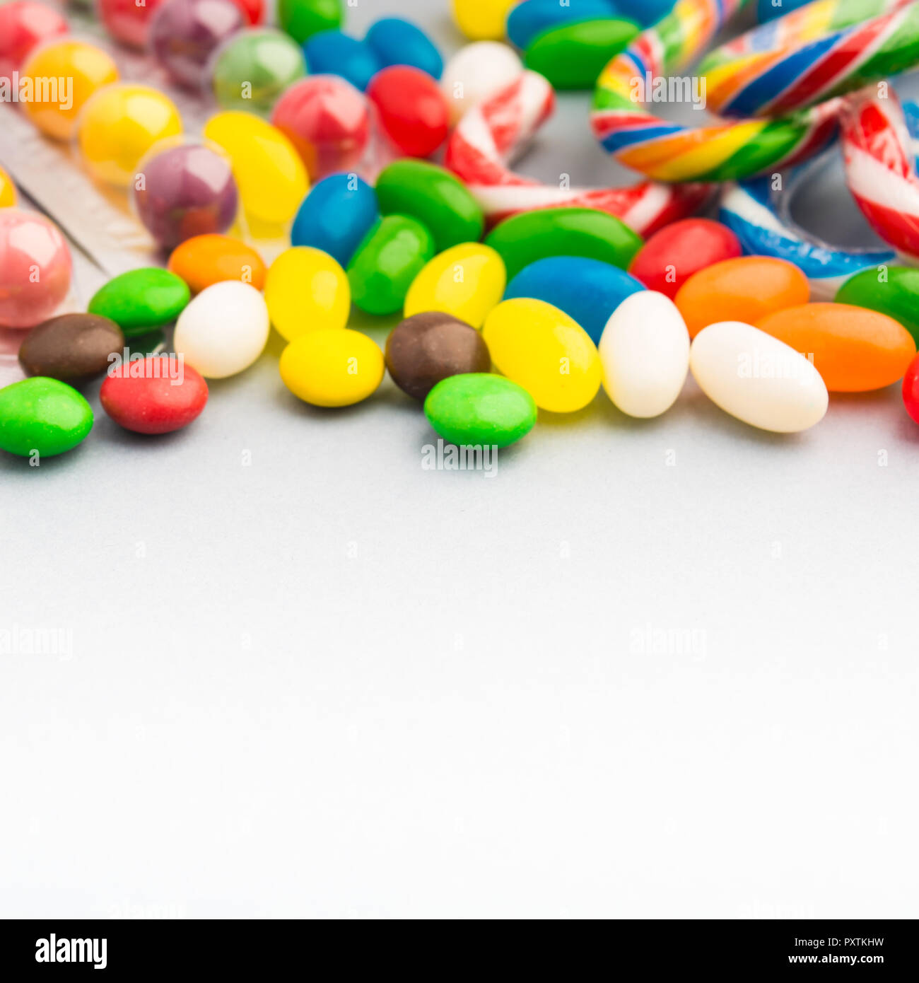 Candies over grey background with copy space, selective focus, square ...