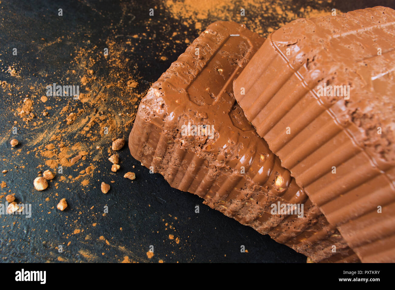 Big blocks of milk chocolate with nuts and copy space over black ...