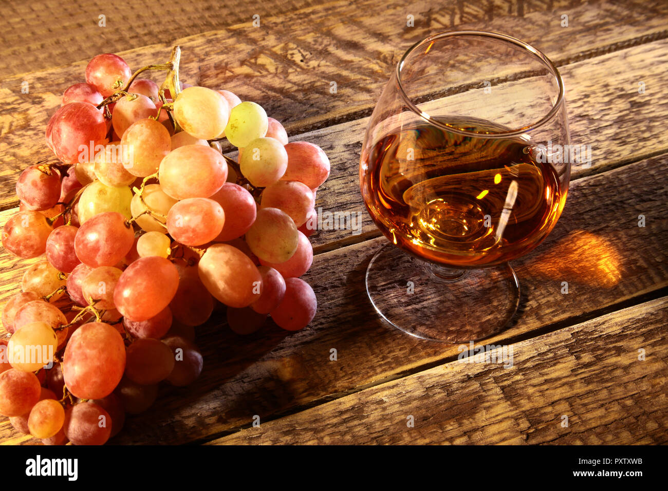 Cognac or Brandy in a glass and fresh grapes, still life in rustic ...