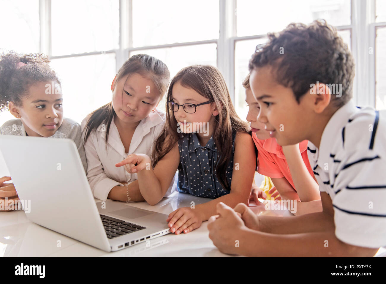 A Group of curious children watching stuff on the laptop screen Stock ...