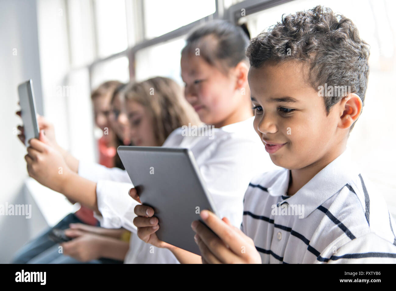 A Group of curious children watching stuff on the tablet screen Stock ...