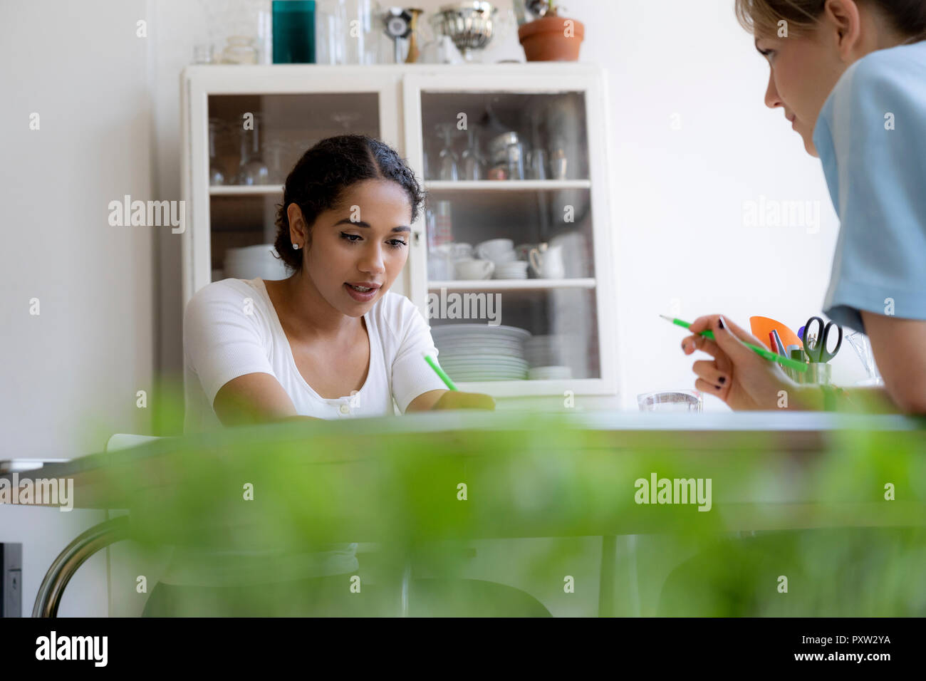 Two friends working at home together Stock Photo - Alamy