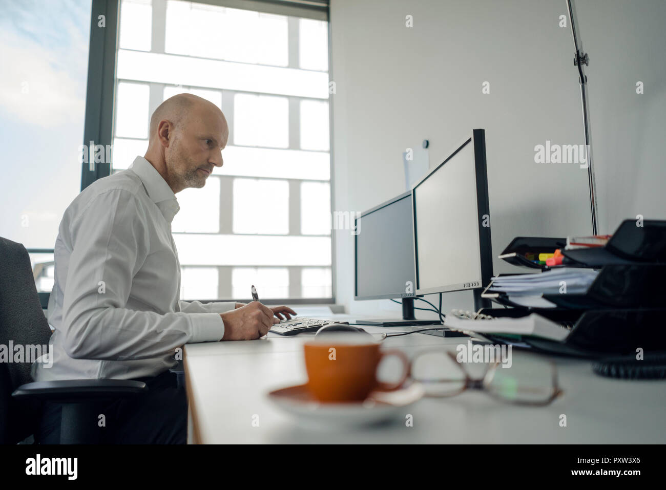 Man on computer making notes hi-res stock photography and images - Alamy