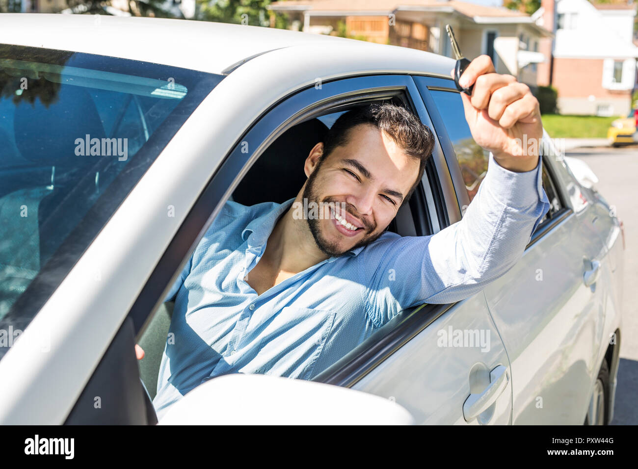 Closeup portrait, young cheerful, joyful, smiling, men holding up keys ...