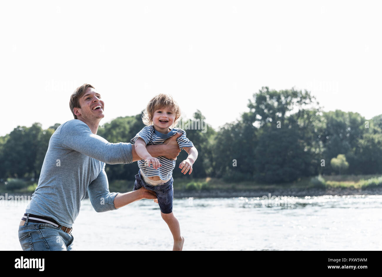 Father and son having fun at the riverside Stock Photo - Alamy