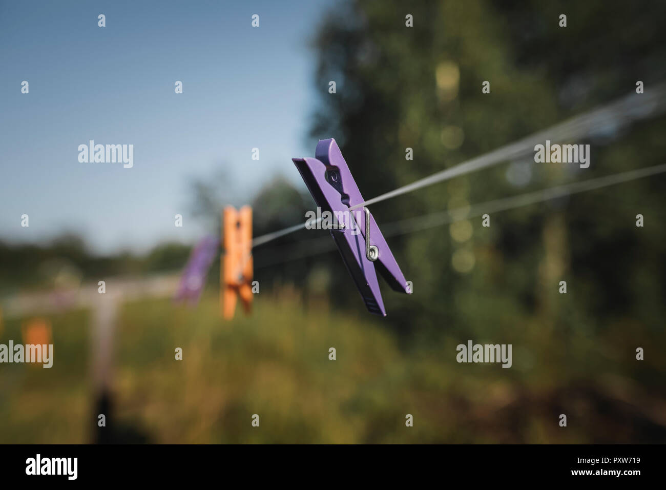 Clothes pegs hanging on washing line Stock Photo - Alamy