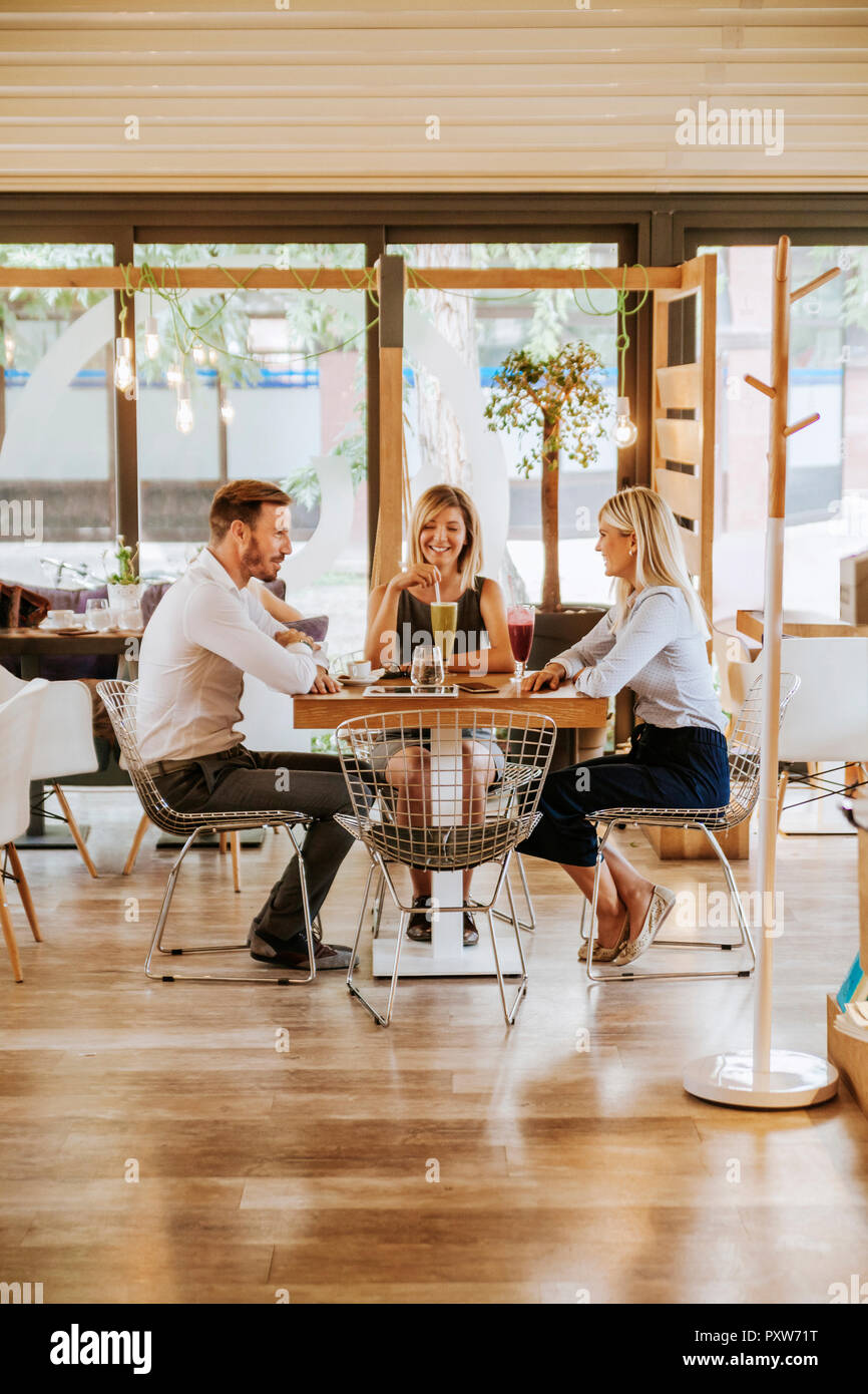Three friends meeting in a cafe Stock Photo - Alamy