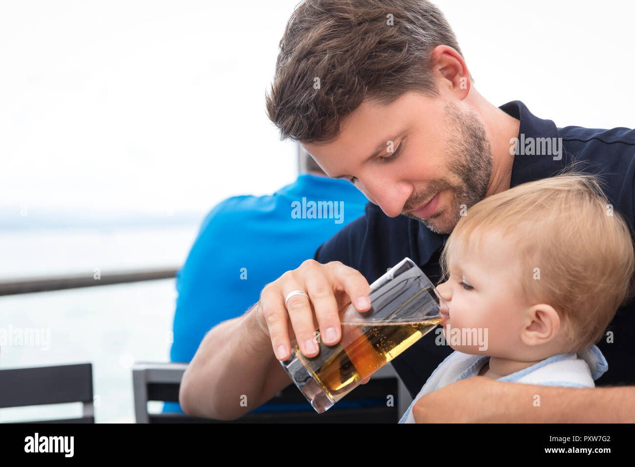 Father giving little daughter something to drink Stock Photo - Alamy