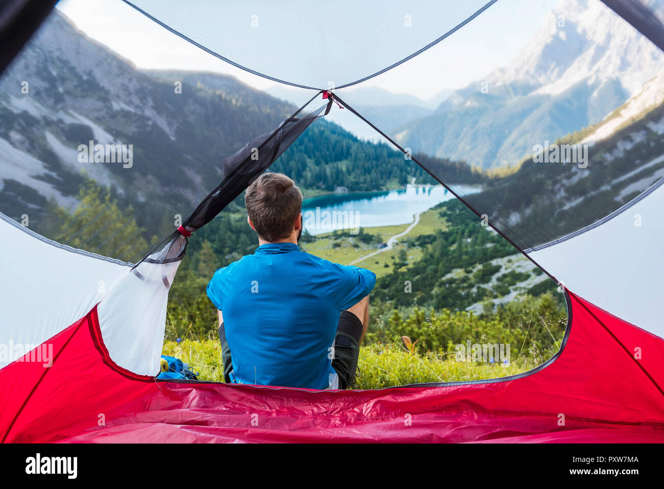 Austria, Tyrol, Hiker relaxing in his tent in the mountains at Lake ...