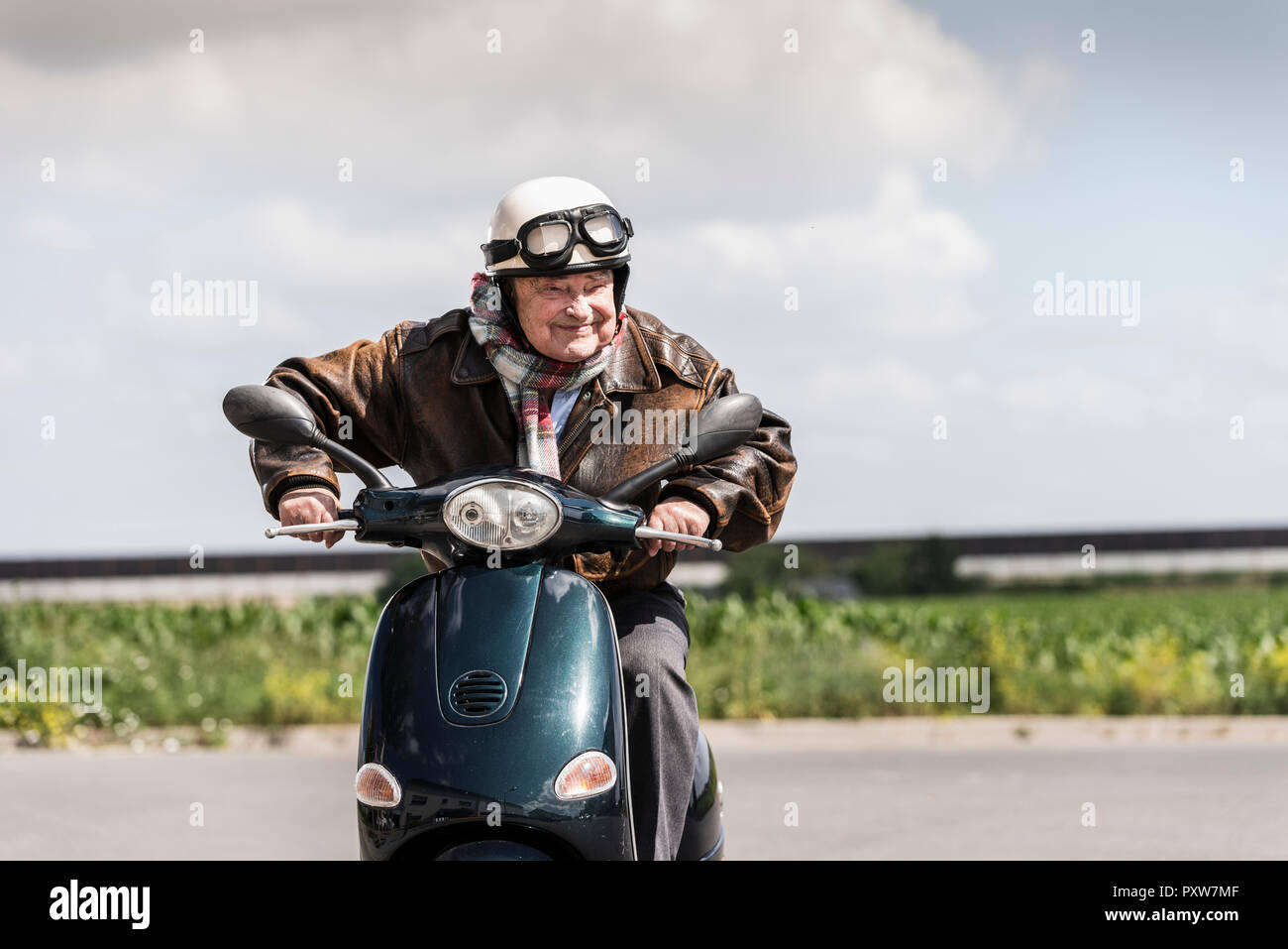 Active senior man speeding on his motor scooter Stock Photo - Alamy