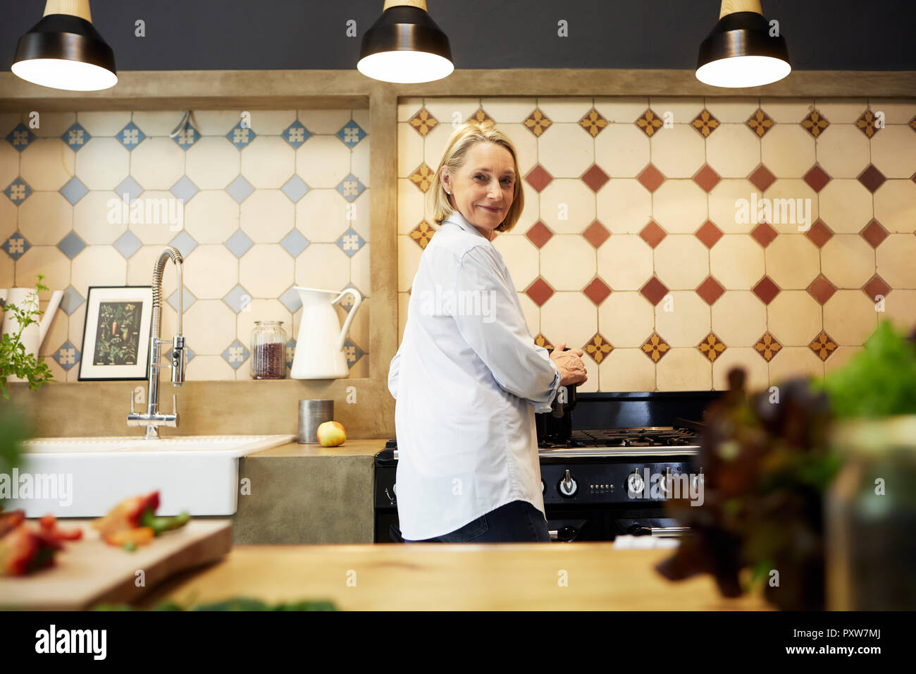 Portrait of smiling mature cooking in kitchen Stock Photo - Alamy