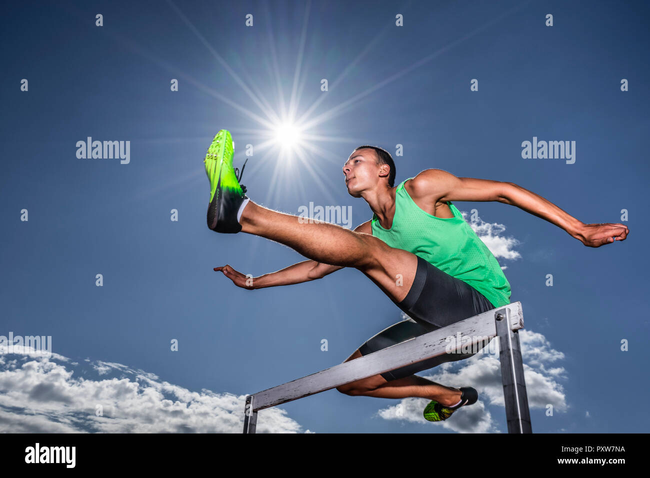 Young runner crossing hurdle hi-res stock photography and images - Alamy