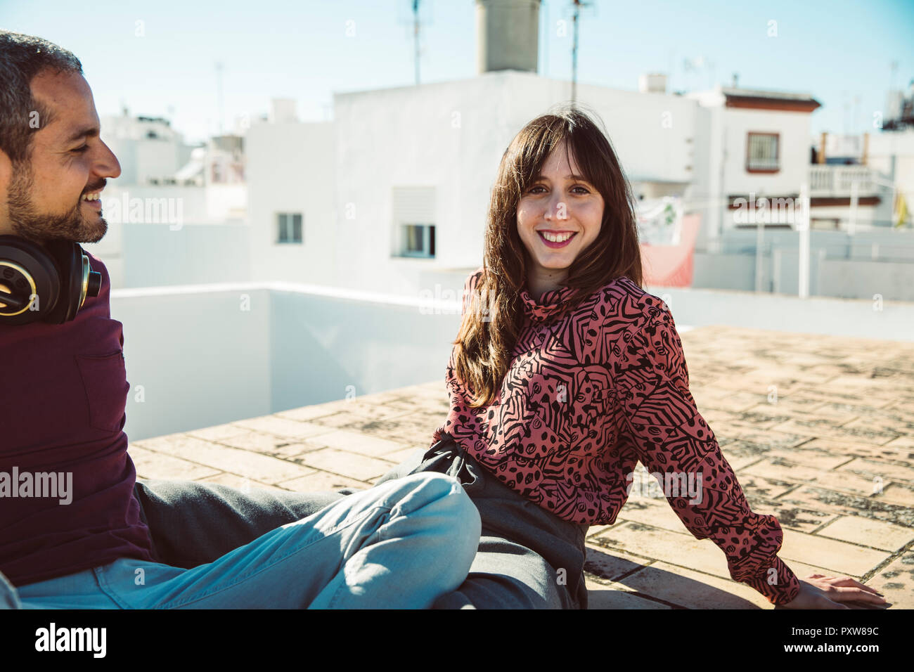 Happy couple sitting roof hi-res stock photography and images - Alamy