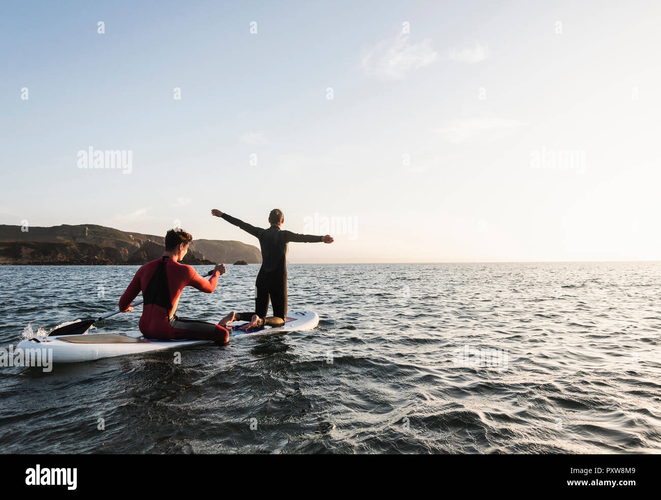 Woman paddleboarding ocean coastline hi-res stock photography and ...