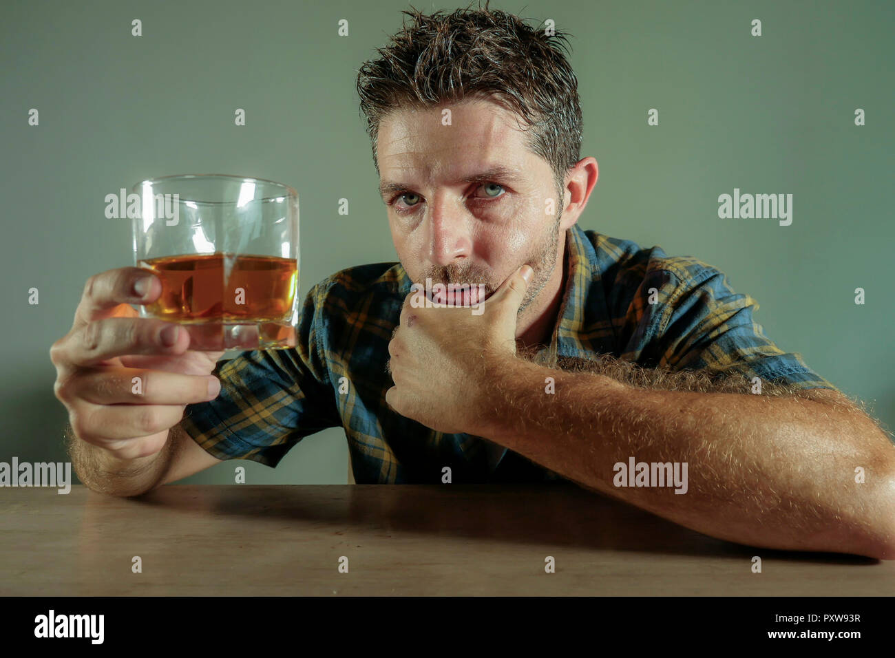 young drunk addict and alcoholic man drinking whiskey glass intoxicated looking wasted tempted ...