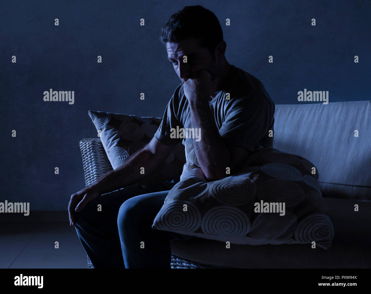 lifestyle dramatic light portrait of young sad and depressed man ...