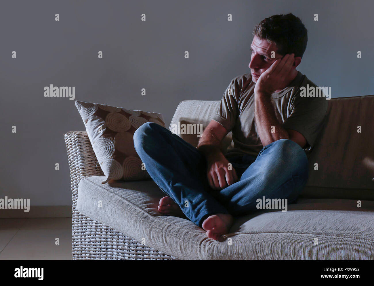 lifestyle dramatic light portrait of young sad and depressed man ...