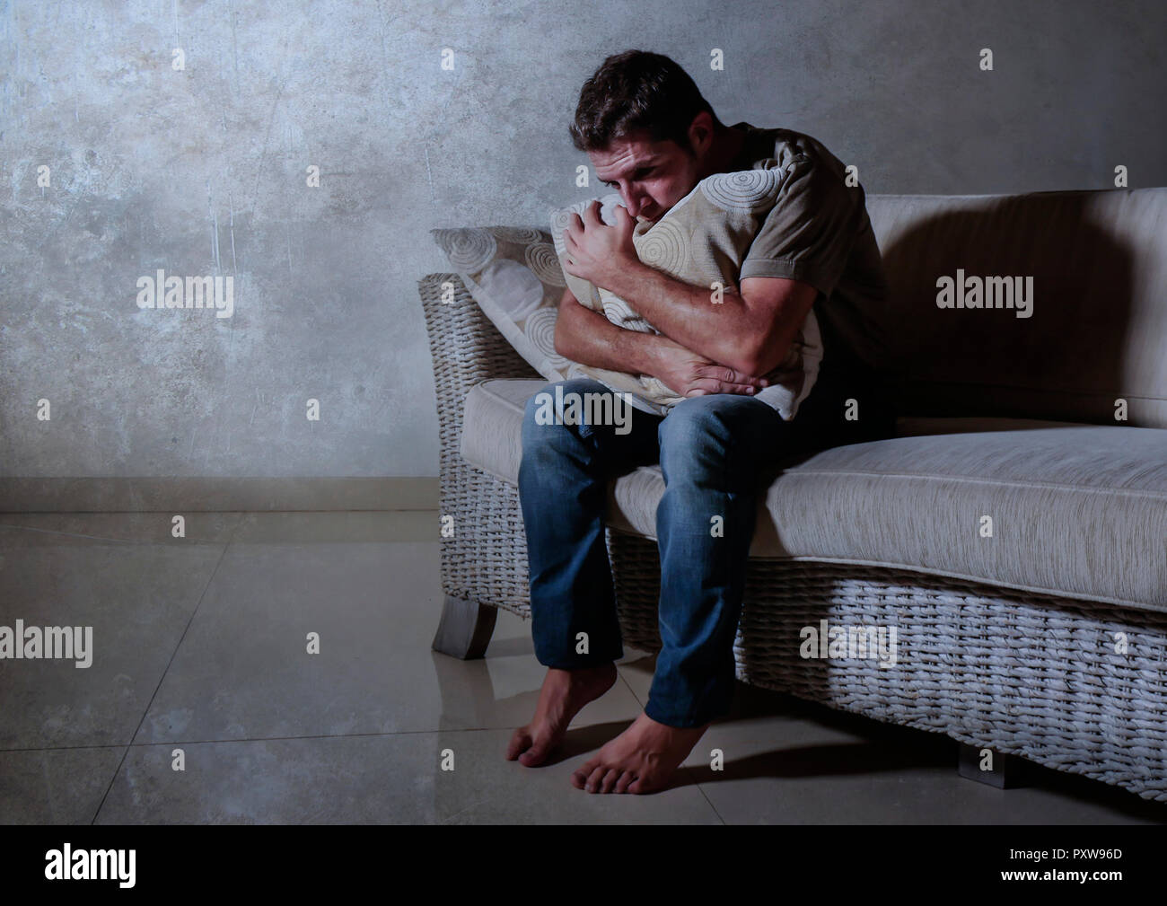 lifestyle dramatic light portrait of young sad and depressed man ...