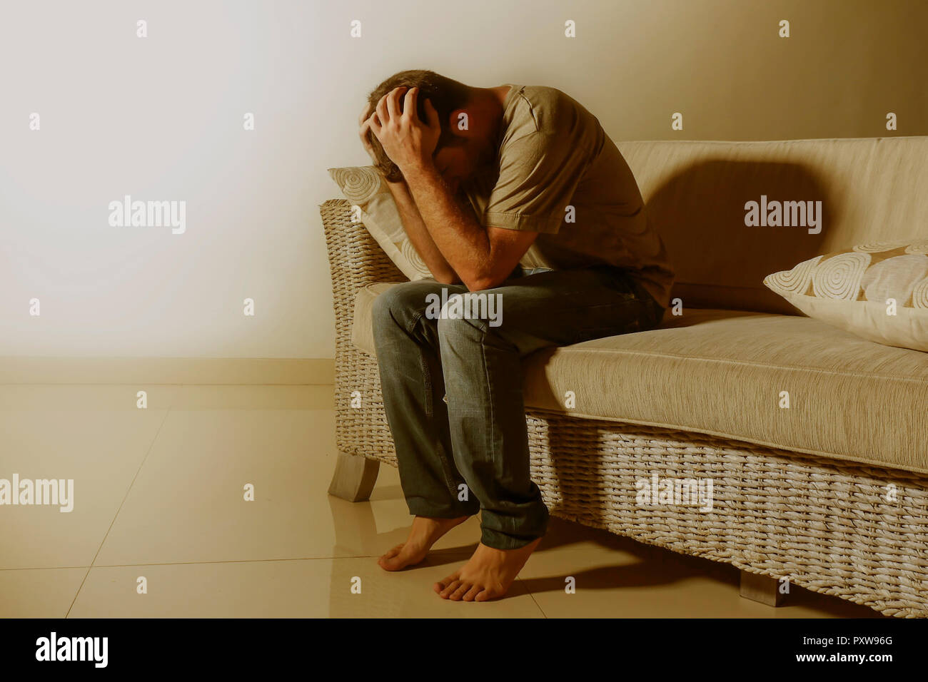 lifestyle dramatic light portrait of young sad and depressed man ...