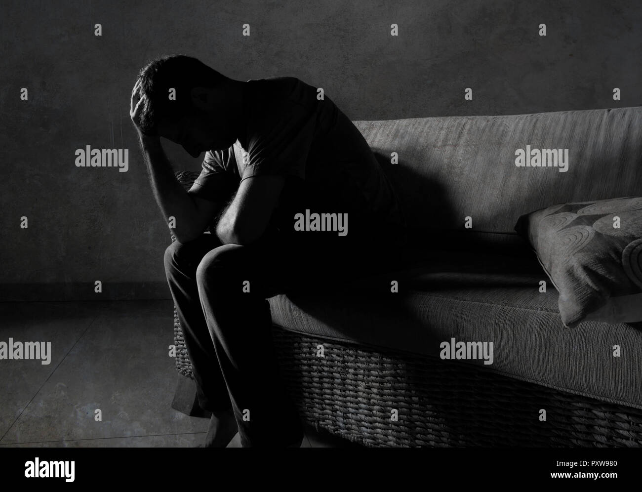 lifestyle dramatic light portrait of young sad and depressed man ...