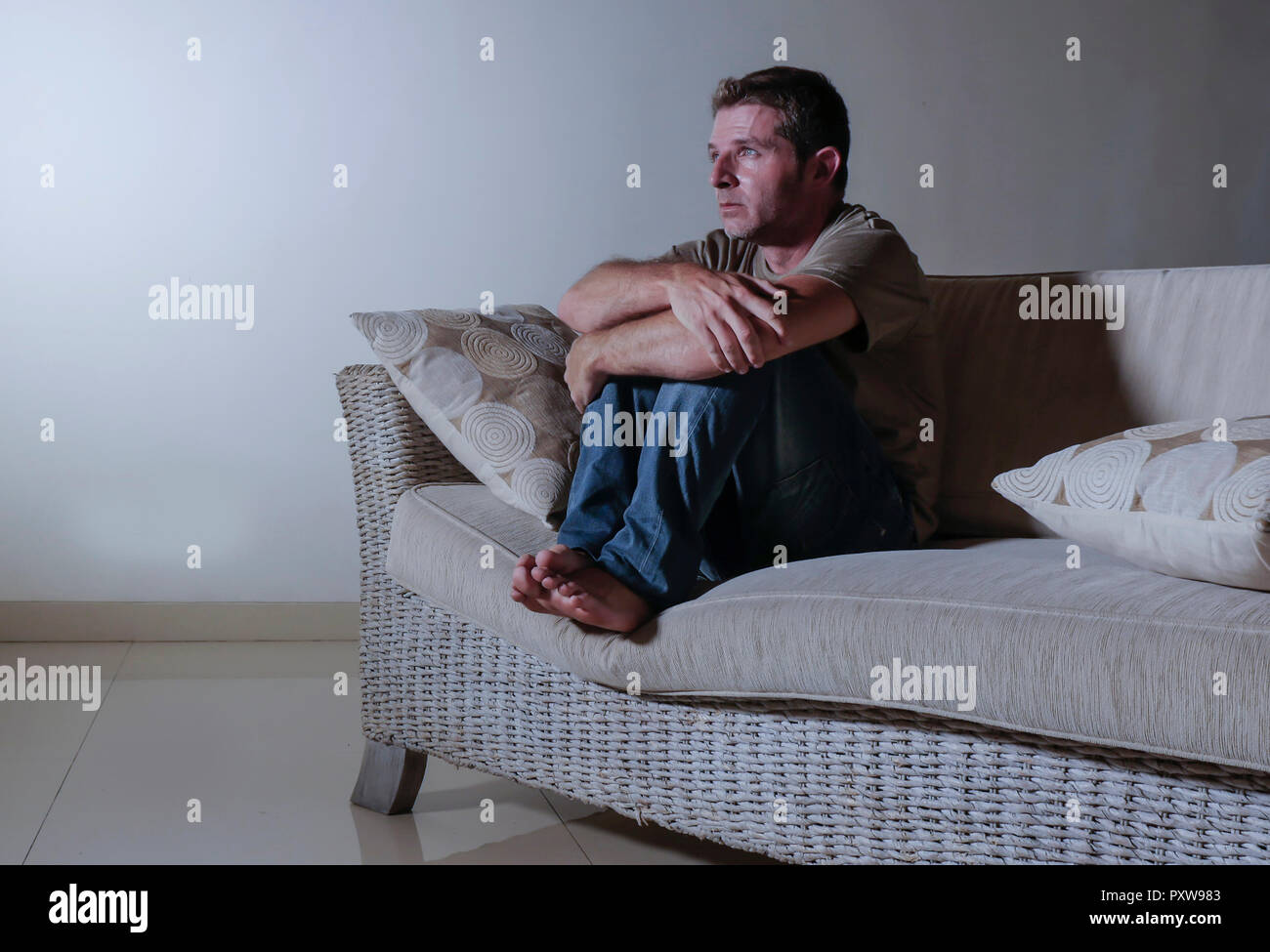 lifestyle dramatic light portrait of young sad and depressed man ...