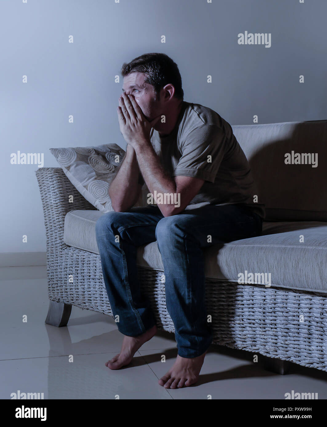 lifestyle dramatic light portrait of young sad and depressed man ...