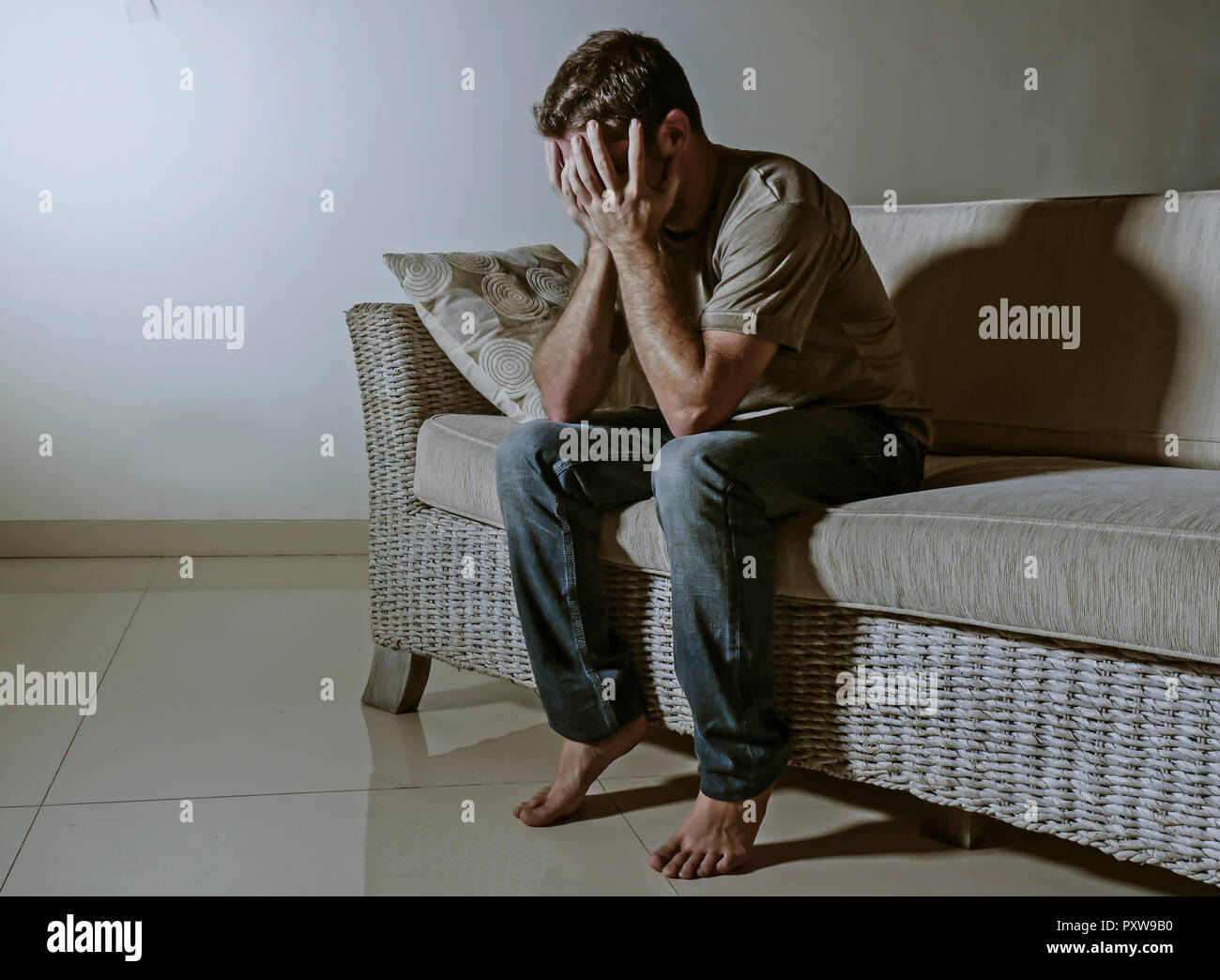 lifestyle dramatic light portrait of young sad and depressed man ...