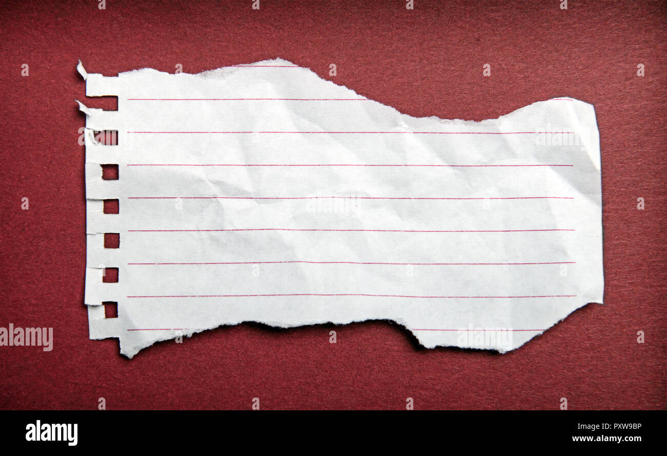 Turn notebook paper on dark red background Stock Photo - Alamy