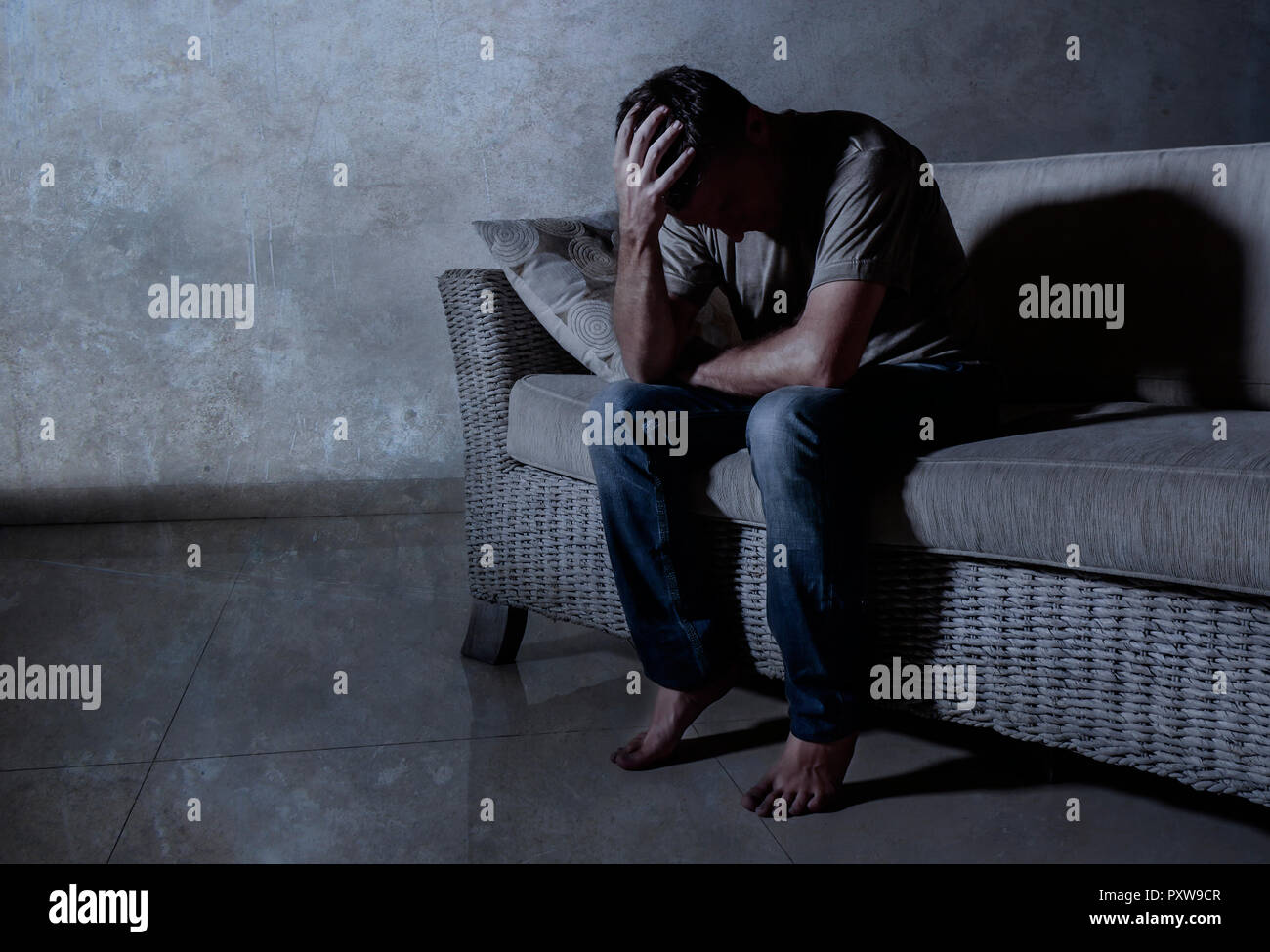 lifestyle dramatic light portrait of young sad and depressed man ...