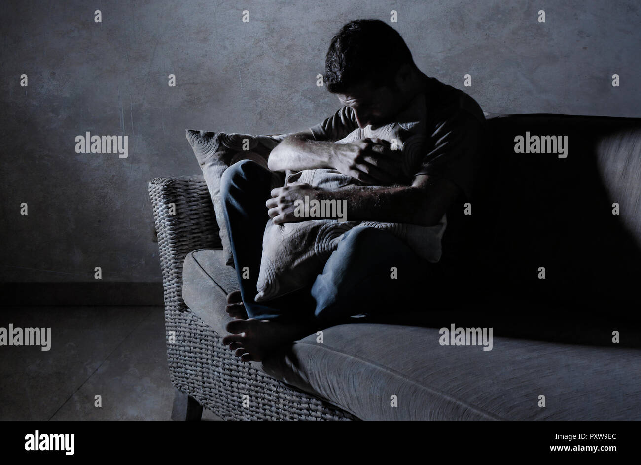 lifestyle dramatic light portrait of young sad and depressed man ...