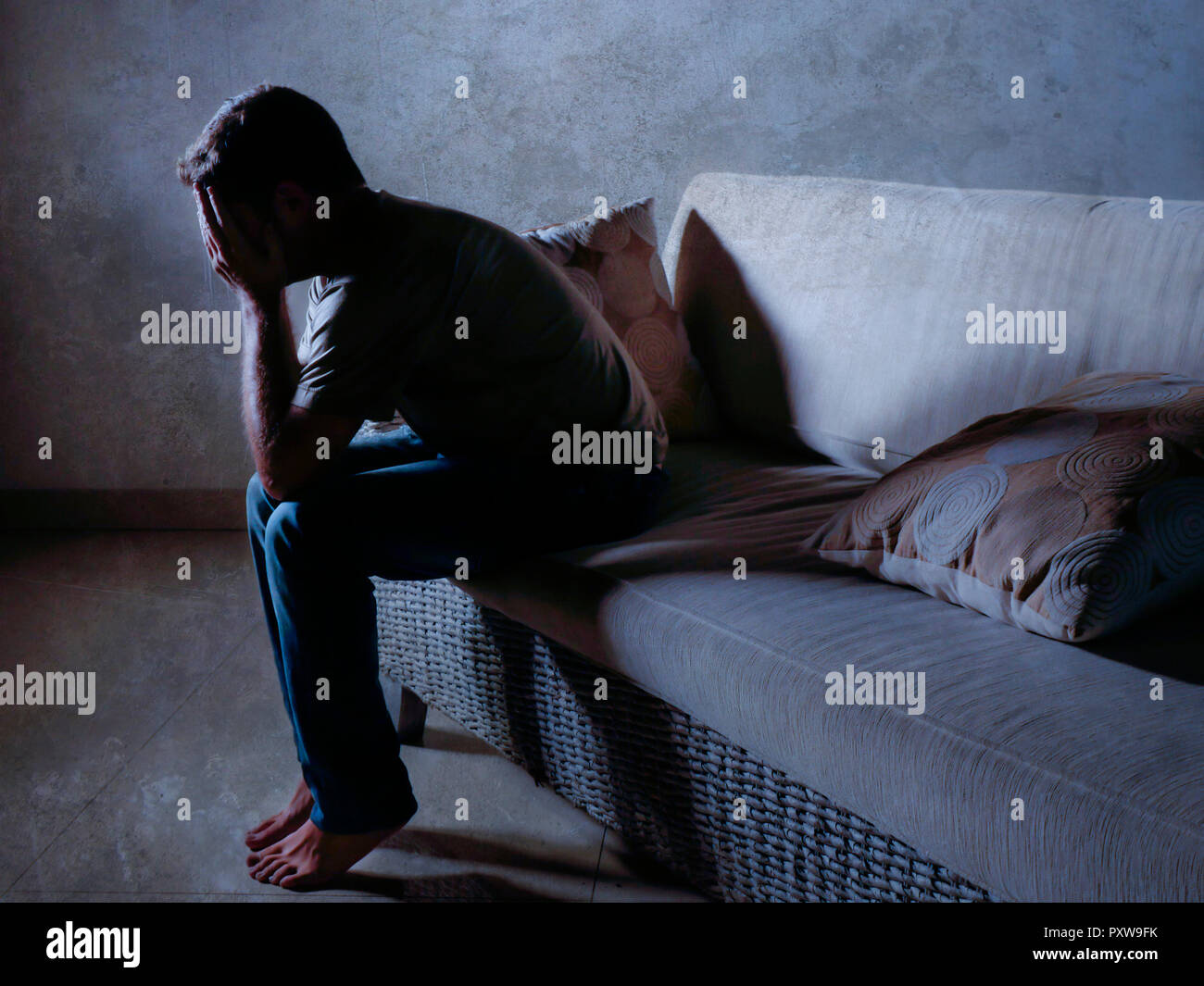 lifestyle dramatic light portrait of young sad and depressed man ...