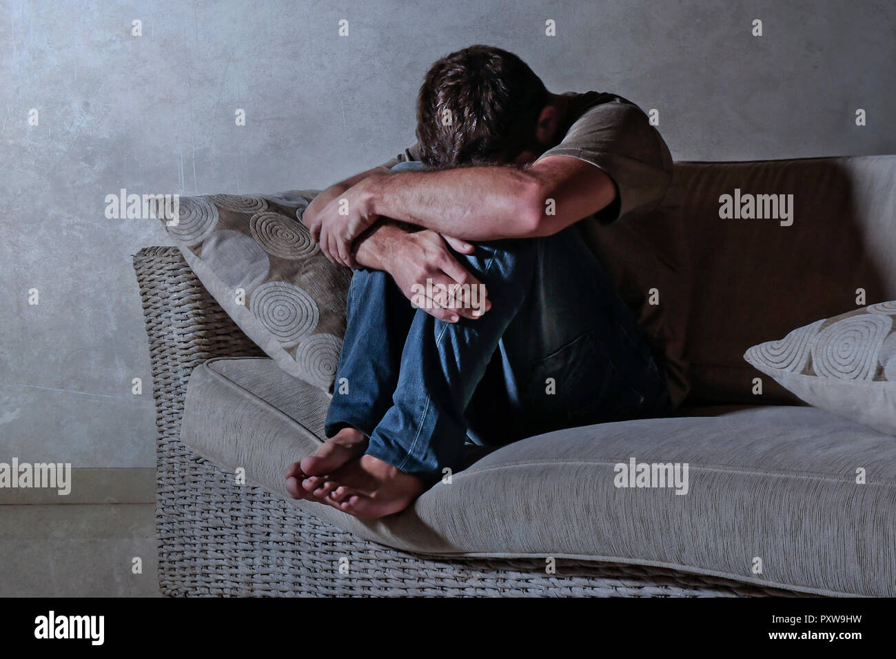 lifestyle dramatic light portrait of young sad and depressed man ...