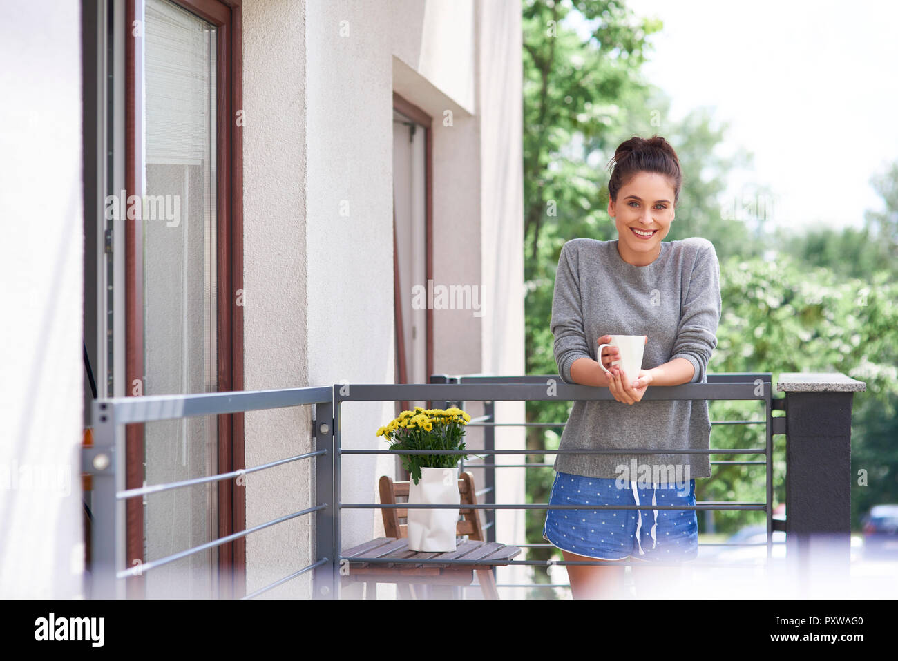 Young woman drinking morning coffee on the balcony Stock Photo - Alamy