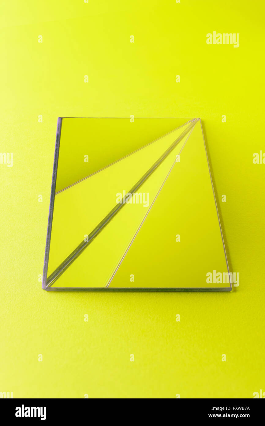 Triangle shaped mirrors over lime green background Stock Photo - Alamy