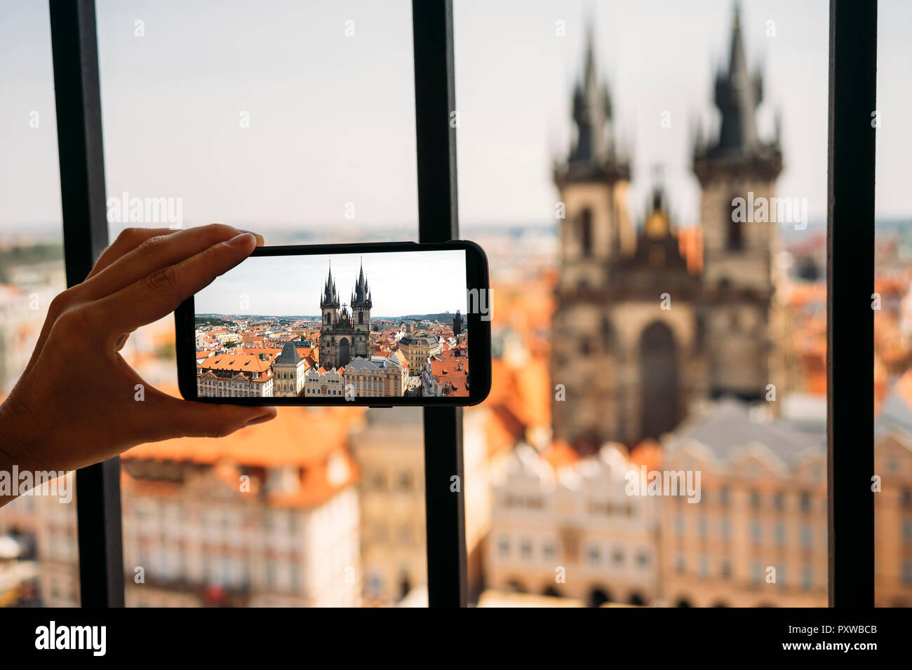 Czechia, Prague, woman taking photo of Church of Our Lady from old town ...