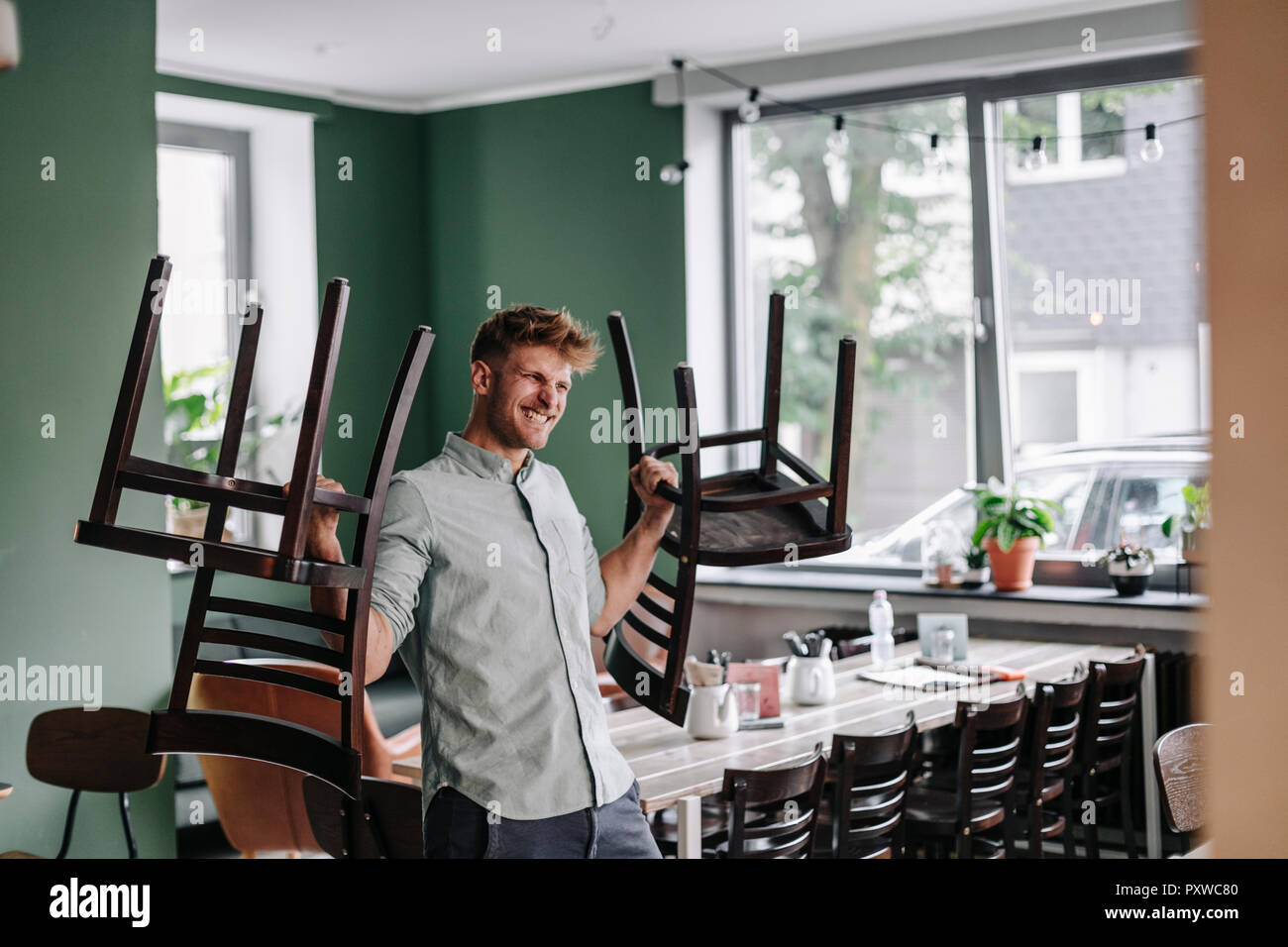 Young business owner lifting chairs hi-res stock photography and images ...