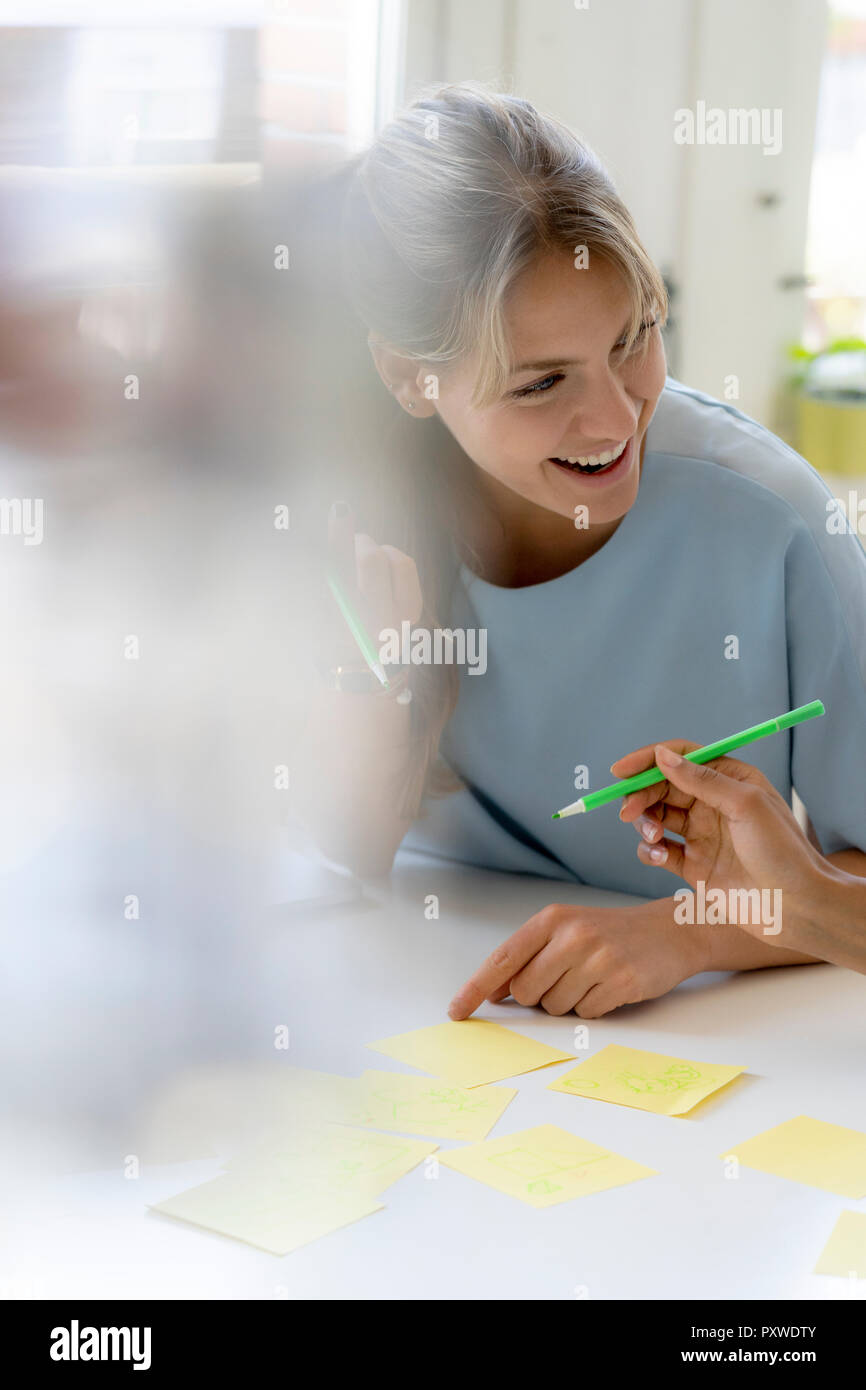 Two friends working at home together, taking notes Stock Photo - Alamy