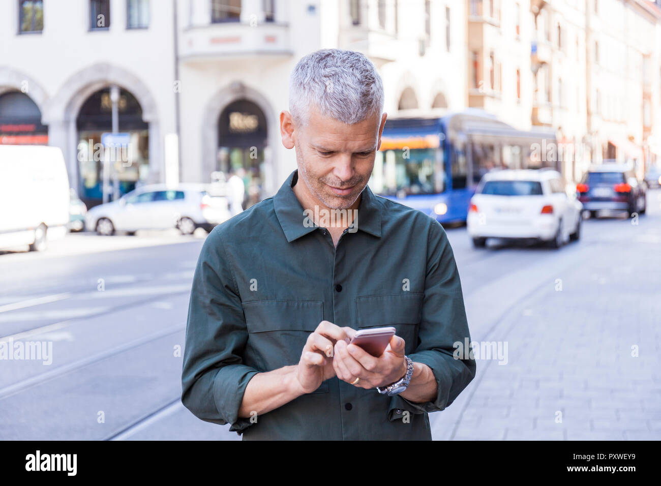 Mature man using cell phone in the city Stock Photo - Alamy