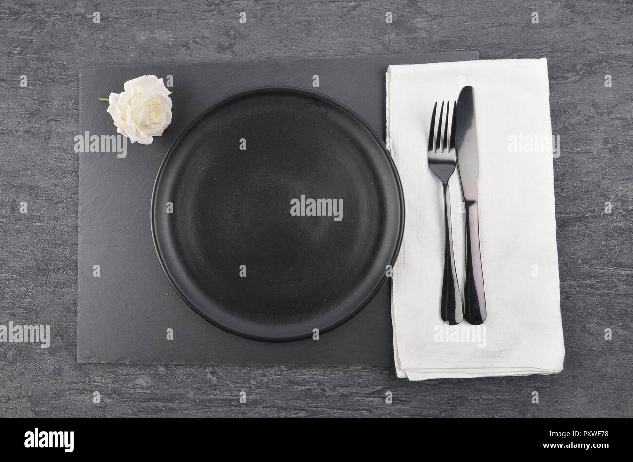 White rose and table setting on slate Stock Photo - Alamy