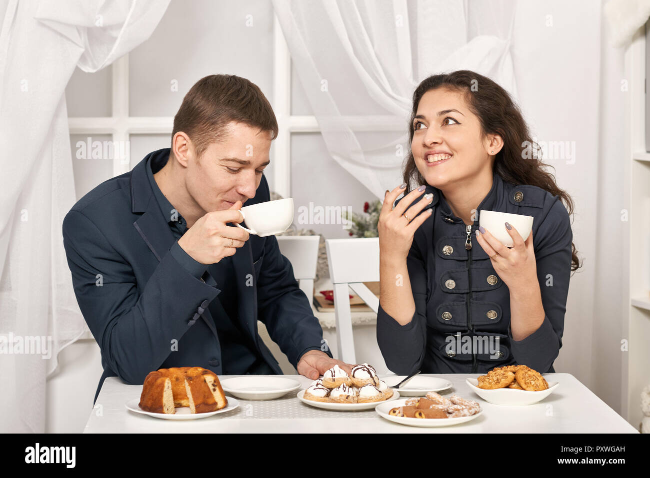 romantic couple drinking tea with cookies and talking Stock Photo - Alamy